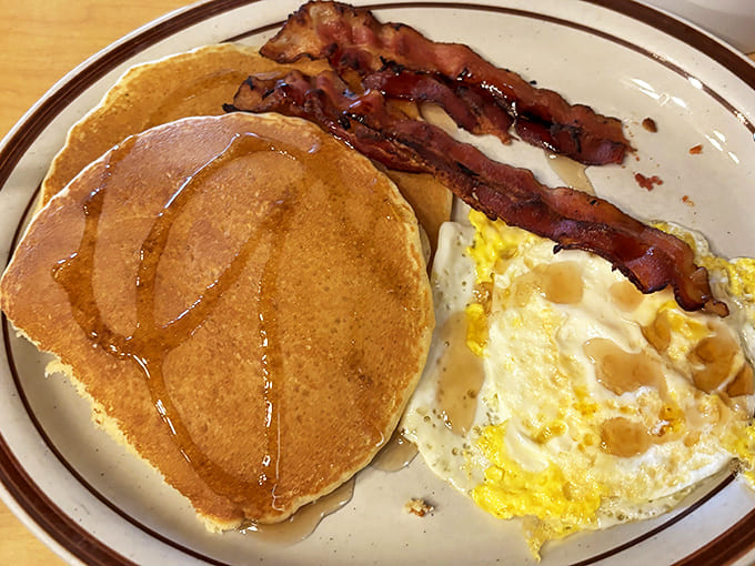 Pancakes so fluffy they practically float, bacon with perfect crisp-to-chew ratio, and eggs sunny enough to brighten your whole day.