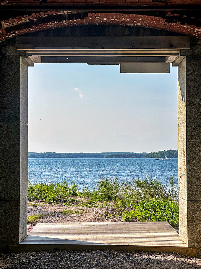 Sunlight streams through an arched passageway, framing a perfect view of Casco Bay's sparkling waters beyond.