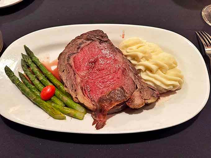 A prime rib cooked to blushing perfection sits alongside bright asparagus and creamy mashed potatoes &ndash; comfort food elevated to an art form.