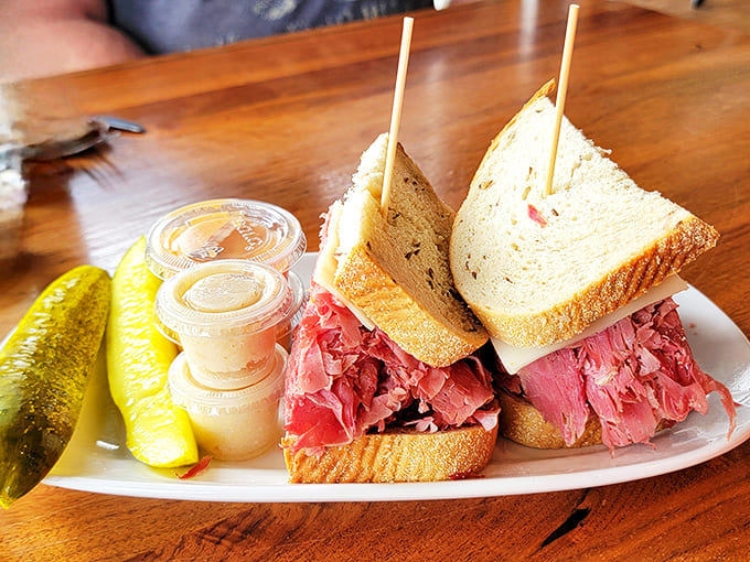 The classic Reuben in all its glory, accompanied by a pickle spear standing guard. That mountain of corned beef isn't just lunch, it's a commitment.