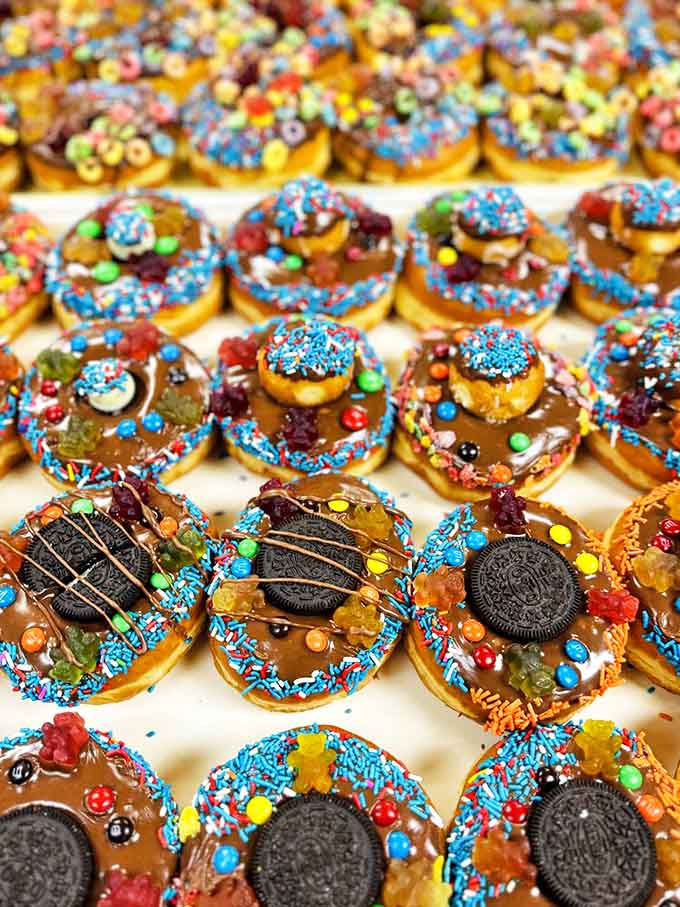 Donut artists unleash their creativity with colorful toppings that transform simple pastries into edible mosaics &ndash; breakfast or dessert? The line deliciously blurs.