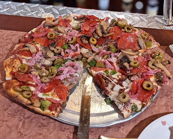 The Director's Choice pizza arrives loaded with colorful toppings &ndash; pepperoni, mushrooms, olives, and peppers creating a symphony of flavors.