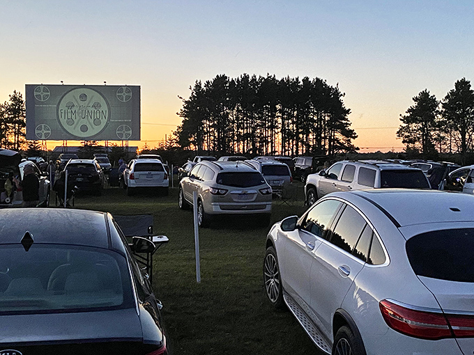 Cars line up facing the big screen at Highway 2 Drive-In, where the lot transforms into an outdoor theater under the open sky.