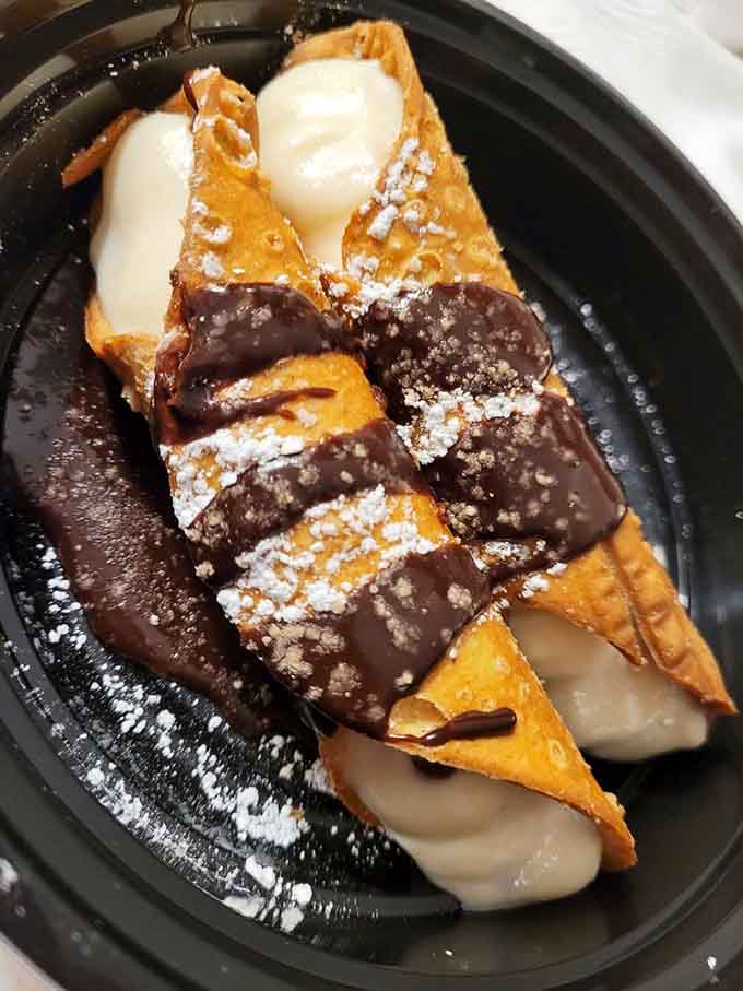Cannoli shells stuffed with sweet ricotta and dipped in chocolate, because ending on a high note matters.