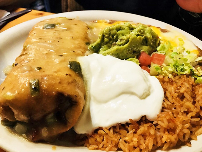 The beef chimichanga arrives like a crispy envelope containing a love letter to Southwestern cuisine, complete with all the fixings.