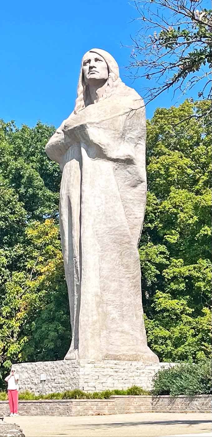 The human figure provides scale to this 50-foot colossus – it's like standing next to a concrete version of an NBA player's big brother.