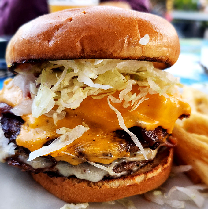 Behold the burger that requires a game plan before eating&mdash;layers of cheese, toppings, and beef stacked higher than your weekend expectations.