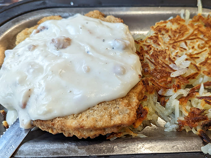 Country-fried steak smothered in peppery white gravy alongside golden hash browns&mdash;comfort food that hugs your soul from the inside out.