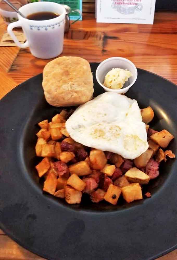 Morning perfection: steaming coffee alongside a hearty bowl of corned beef hash and a fluffy biscuit. Breakfast doesn't get better than this.