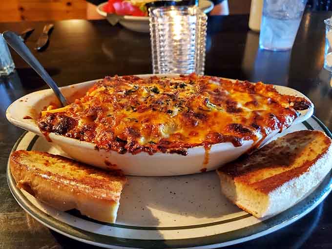 Bubbling mac and cheese with a caramelized top is comfort food elevated to art, served with garlic toast for carb-on-carb joy.