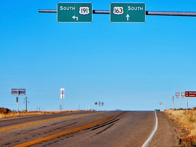 Two yellow lines stretch toward the horizon like parallel sunbeams, guiding adventurers through Arizona's magnificent desolation.
