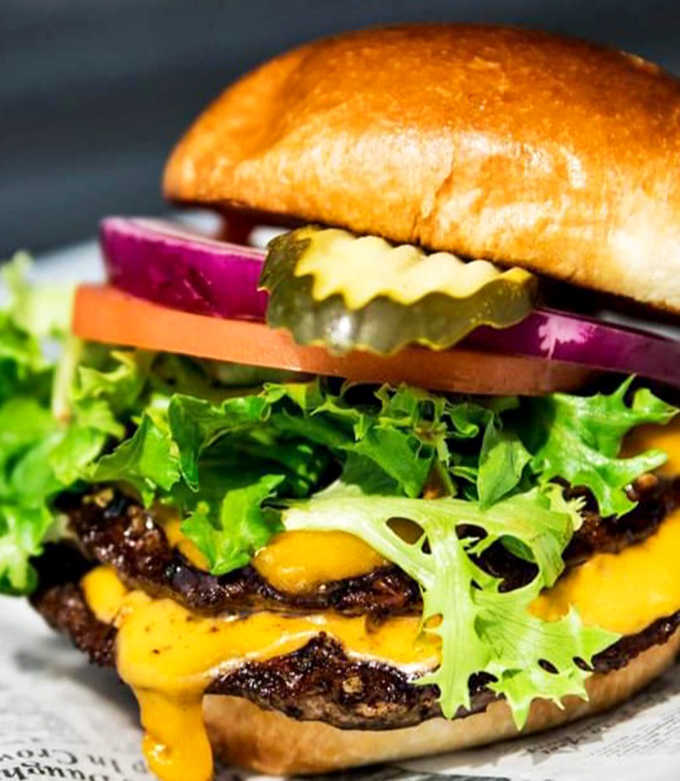 The Dockside Deluxe burger proves this seafood haven knows its way around land fare too &ndash; juicy, cheesy, and demanding both hands.