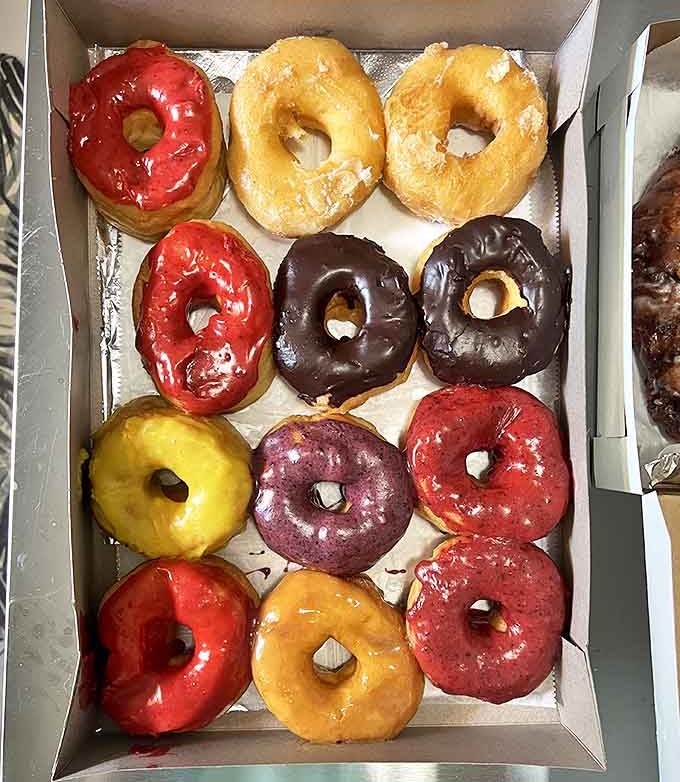 A dozen varieties of colorful donuts showcase D&D's range, from classic chocolate to vibrant fruit-glazed creations that taste as good as they look.