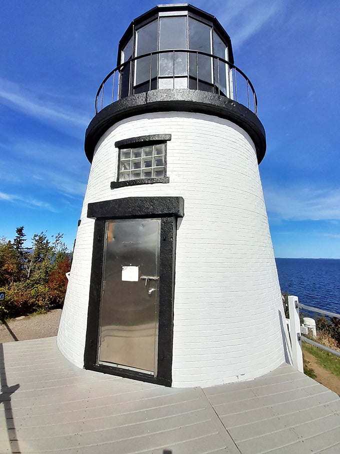 The lighthouse entrance beckons curious explorers, its simple doorway a portal to centuries of maritime stories and seafaring lore.