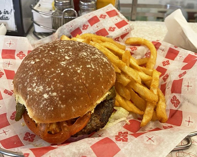 A burger that demands two hands and zero distractions, paired with fries so golden they deserve their own currency.