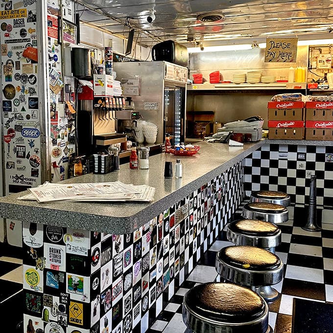 The classic checkerboard counter invites solo diners to perch on swiveling stools for front-row views of short-order cooking magic.