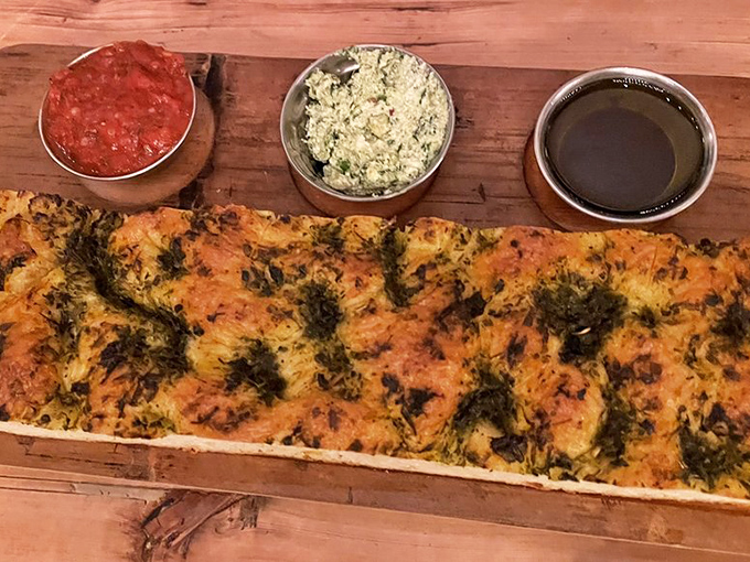 Golden, herb-flecked focaccia that's worth fighting over, served with dipping accompaniments that elevate bread from side to star.