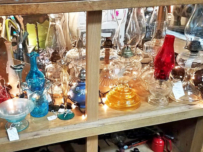 Vintage oil lamps in jewel tones catch the light like liquid gemstones. Each one holds not just oil, but the warm glow of evenings before electricity ruled our lives.