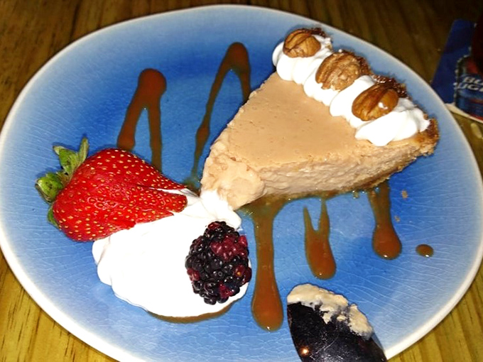 The Guava Lime Pie arrives artfully presented, its smooth, sunset-colored filling nestled in a buttery graham cracker crust that provides perfect contrast.