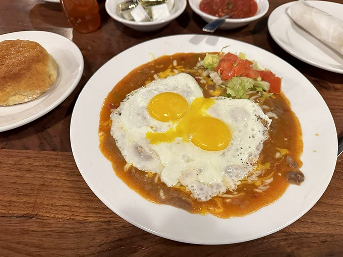 Two sunny-side eggs crown this ranchero masterpiece, with a fresh-baked biscuit standing by to soak up every last drop of that liquid gold.
