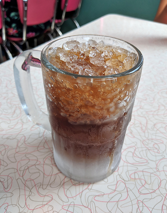 The root beer's frothy head and caramel color hint at the complex flavors waiting beneath – this isn't your average soda fountain drink.