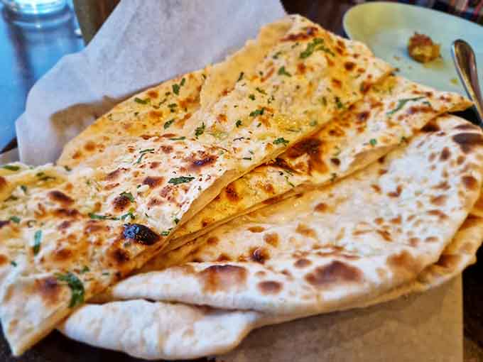 Fresh naan bread straight from the tandoor oven, pillowy soft with those characteristic charred spots that make it absolutely irresistible for sopping up curry.