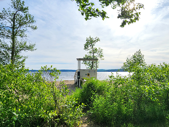A lifeguard station waits sentinel-like at the water's edge, framed by greenery and lake views. Safety with a spectacular backdrop.
