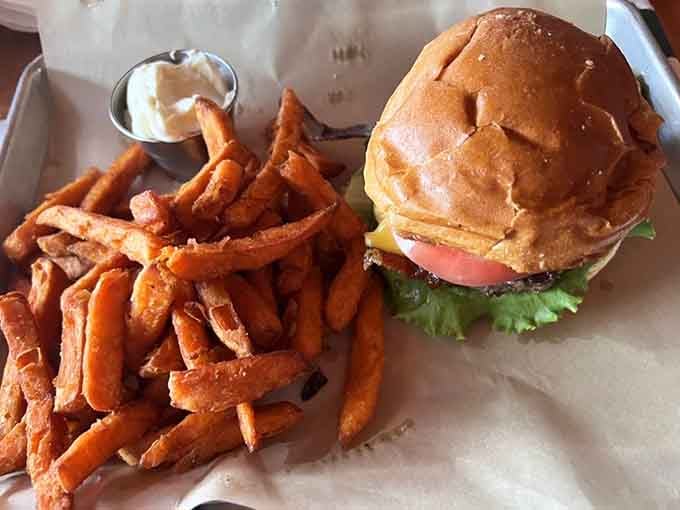 Golden fries pile high next to a burger that's basically edible happiness, making this plate a masterpiece of comfort food.