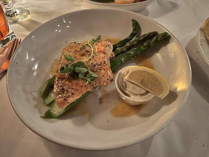 Norwegian salmon that looks like it swam all the way from Scandinavia just to land on your plate, accompanied by asparagus standing at attention like delicious green soldiers.