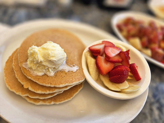 Pancakes so fluffy they practically hover above the plate, with butter melting into golden pools of breakfast perfection.