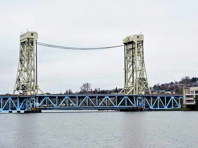 The engineering marvel that is the Portage Lake Lift Bridge connects sister cities with mechanical grace, its blue framework a signature of the skyline.