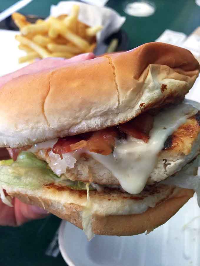 The grilled chicken club arrives like a skyscraper of flavor, architecturally sound and delicious on every level.