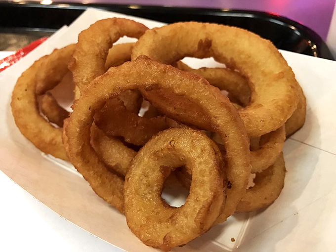 These golden onion rings form a tower of crispy perfection that would make the Leaning Tower of Pisa jealous of their structural integrity.