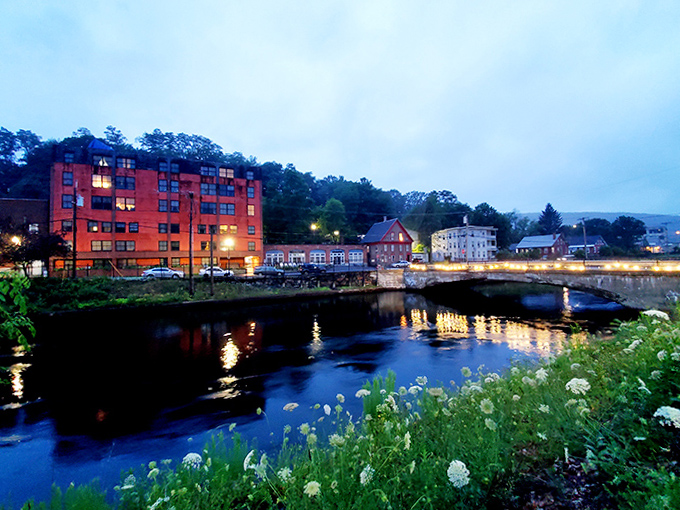 As twilight falls, riverside buildings glow with warmth, their reflections dancing on water that has witnessed centuries of human stories.
