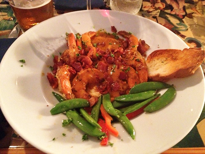 Plump shrimp nestled on a bed of creamy grits with crisp vegetables—comfort food elevated to art form.