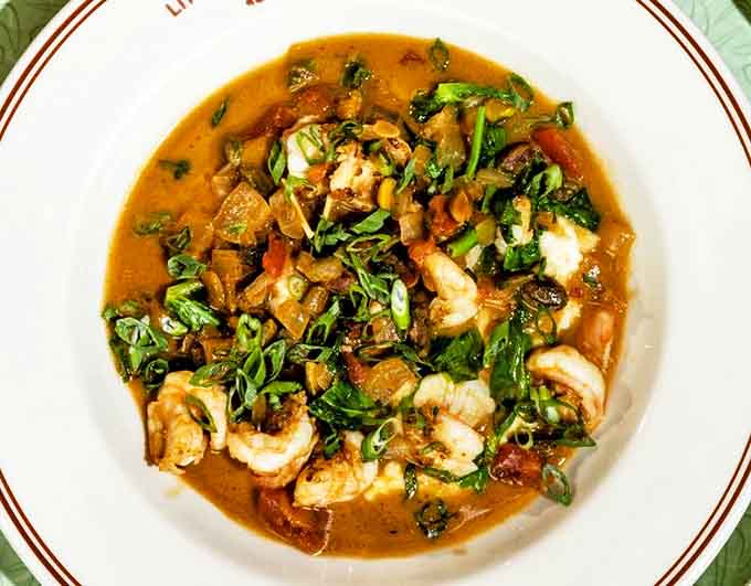 Plump shrimp nestled in creamy grits with sweet corn and scallions &ndash; Southern comfort reimagined with chef-driven precision and care.