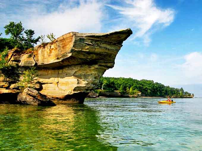 Morning light bathes Turnip Rock in golden hues, highlighting the impossible balance of stone and living forest in this natural Michigan marvel.
