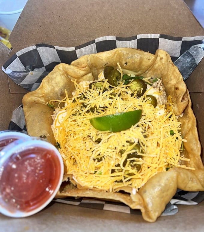 A crispy fry bread bowl cradles fresh ingredients like a protective parent &ndash; proving that "salad" can be both virtuous and indulgent simultaneously.