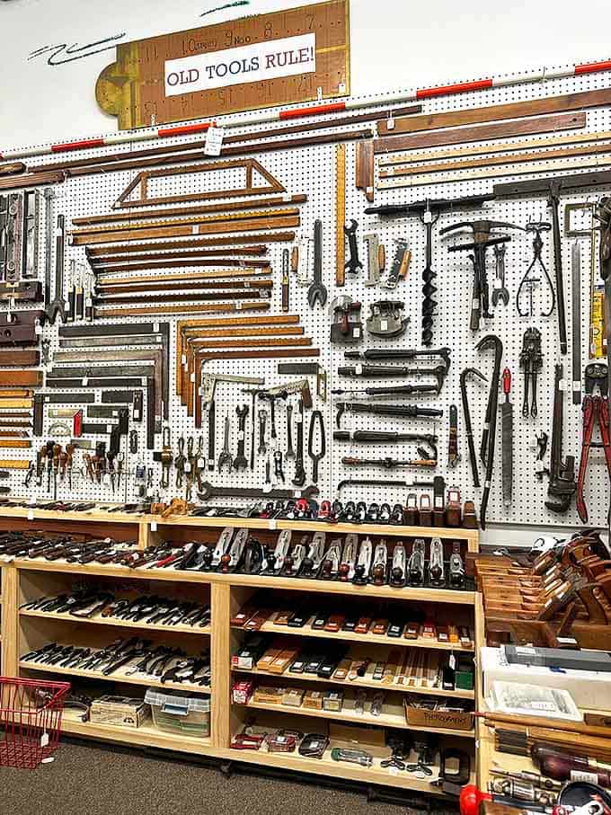 "Old Tools Rule!" proclaims the sign, and this magnificent wall of vintage implements proves why craftsmanship never goes out of style.