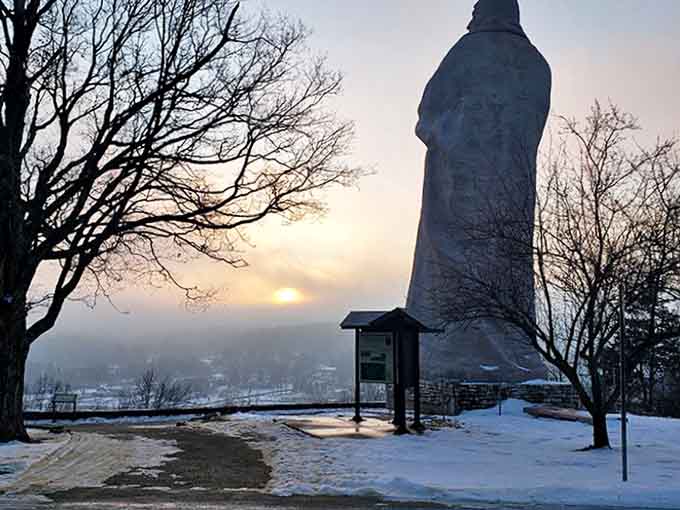 Winter transforms the statue into a snow-dusted monument, its stoic silhouette even more dramatic against the muted winter landscape.