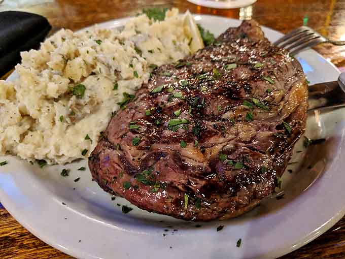The ribeye steak sits there looking absolutely magnificent, like it's posing for its glamour shots before disappearing forever.