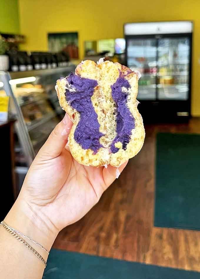 An ube-filled bismark reveals its vibrant purple treasure, the Filipino-inspired filling adding an exotic twist to the classic donut experience.