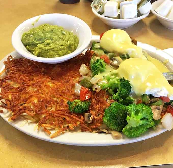 Veggie Eggs Benedict with Avocado: Garden-fresh vegetables dance beneath poached eggs and hollandaise &ndash; proof that meatless breakfasts can be decadently satisfying.