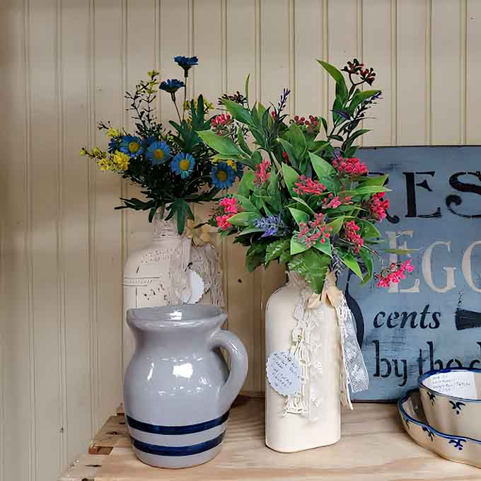 Vintage vases and artificial blooms create vignettes of nostalgia, transforming ordinary shelves into miniature time capsules of domestic beauty.