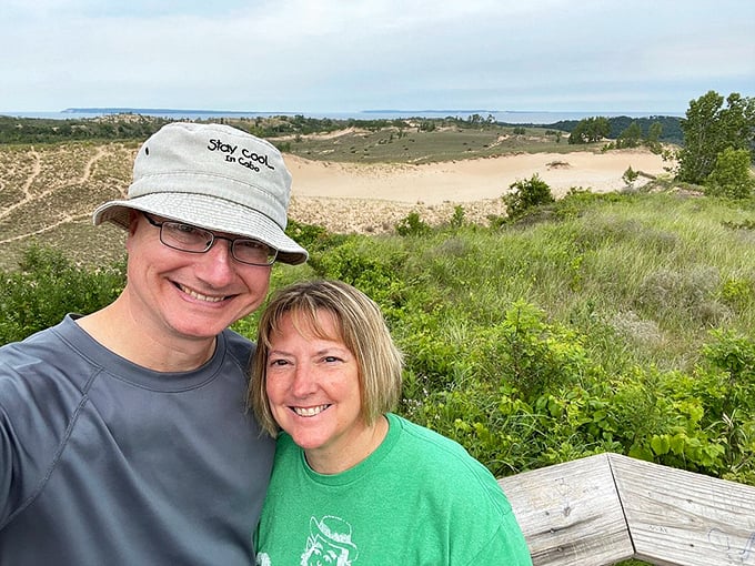 Happy explorers pause to capture the moment at the dune overlook, where Michigan's landscape performs its most impressive magic trick.