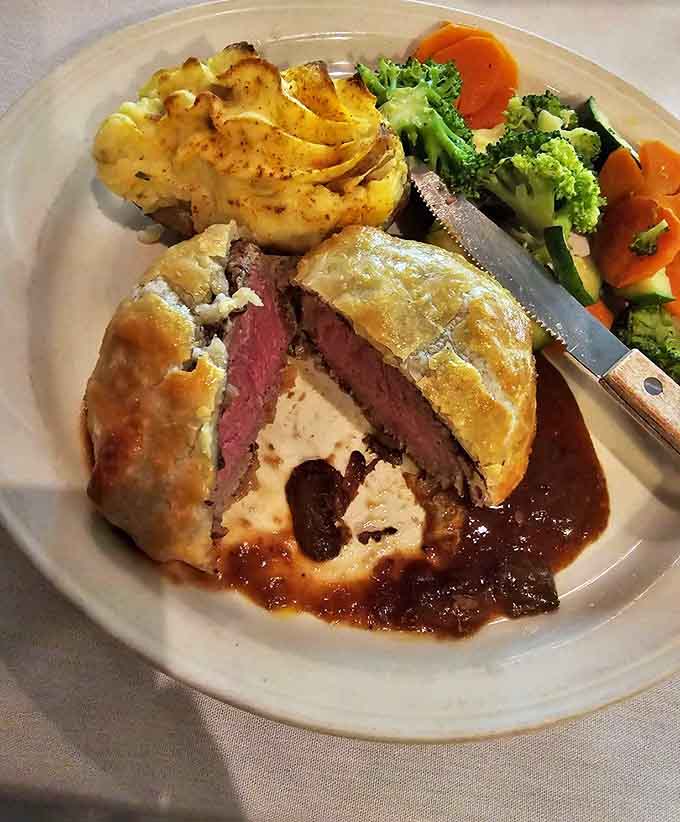 Pastry peeled back reveals the Wellington's blushing interior &ndash; a perfect medium-rare that makes meat lovers weak at the knees.