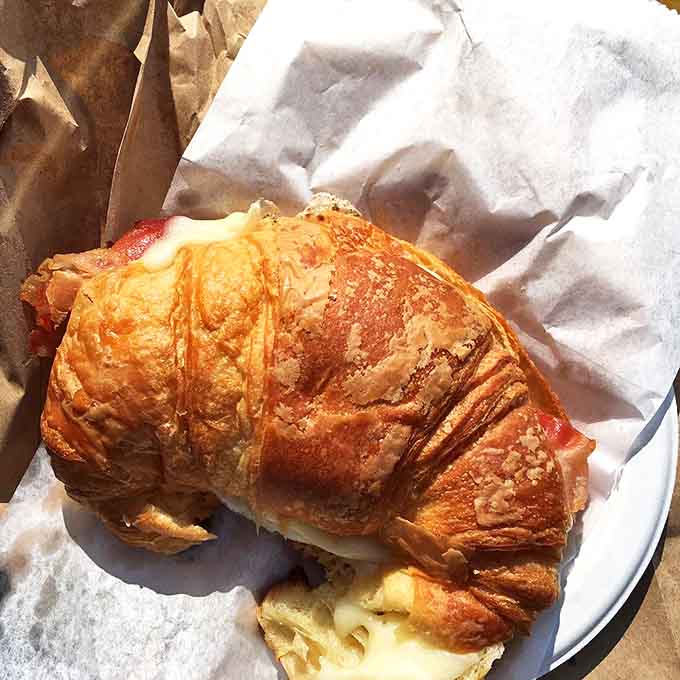 Bacon, egg, and cheese croissant: Morning salvation arrives in buttery layers – the breakfast sandwich that makes hitting the snooze button worth it.