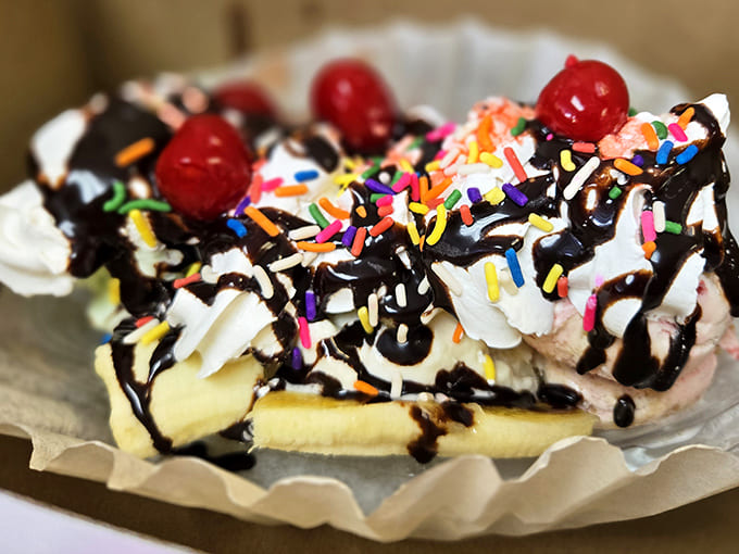 Ice cream architecture at its finest &ndash; whipped cream mountains, chocolate rivers, and cherry summit markers create a dessert worth conquering.