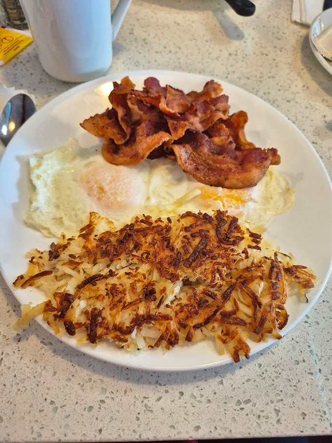 The holy trinity of breakfast perfection: crispy bacon, eggs cooked just right, and hash browns with that magical crisp-yet-tender texture.