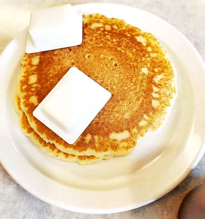 Pancakes so fluffy they practically float off the plate, with butter slowly melting into their warm, tender centers.